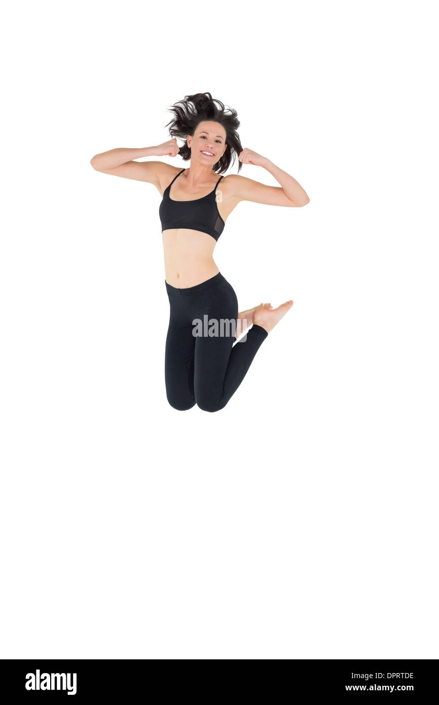 Sporty young woman jumping over white background Stock Photo - Alamy