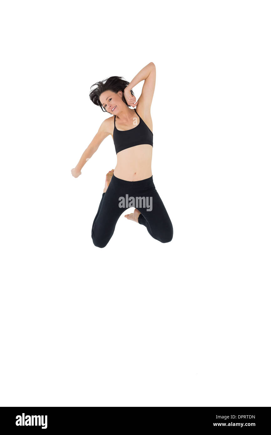 Sporty young woman jumping over white background Stock Photo - Alamy
