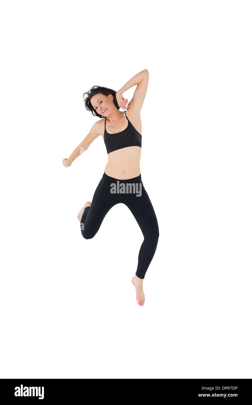 Sporty young woman jumping over white background Stock Photo - Alamy