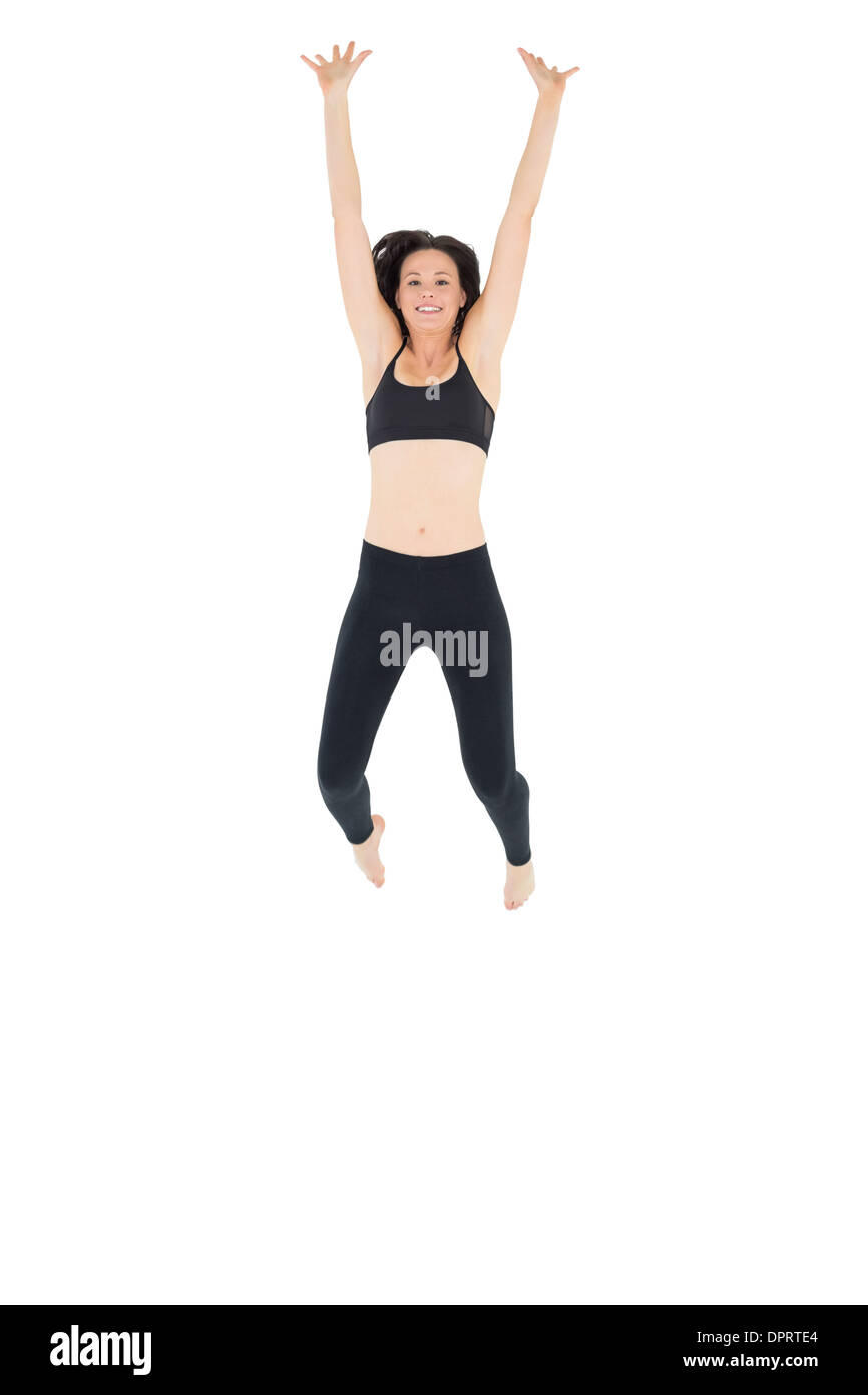 Sporty young woman jumping over white background Stock Photo - Alamy