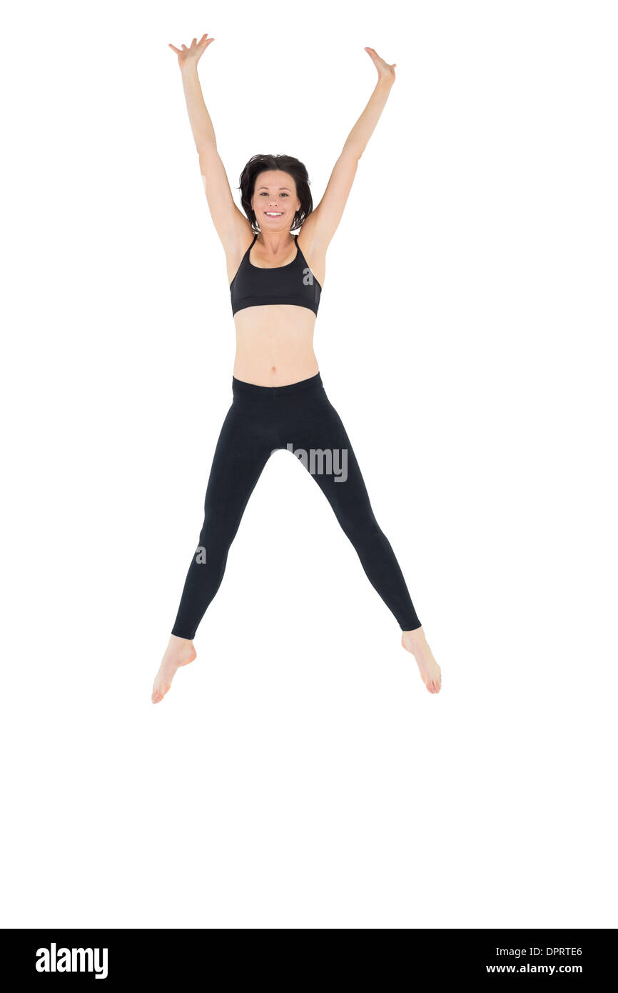Sporty young woman jumping over white background Stock Photo - Alamy