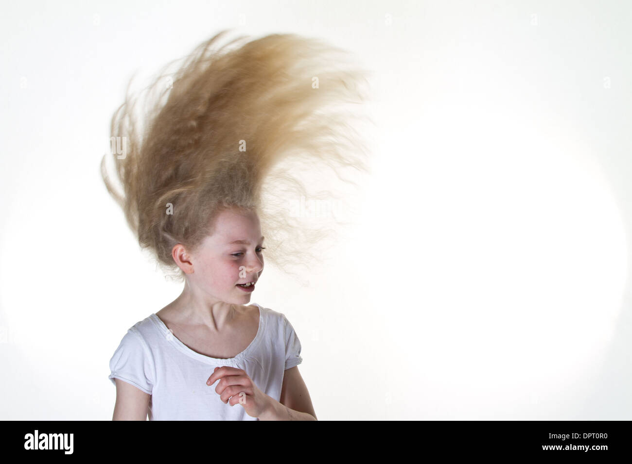 Girl dancing with hair in the air white background; shot in studio ...