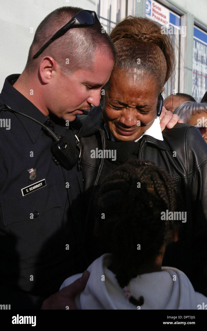 Oakland Police officer Tim Scarrott, left, comforts Oakland resident ...