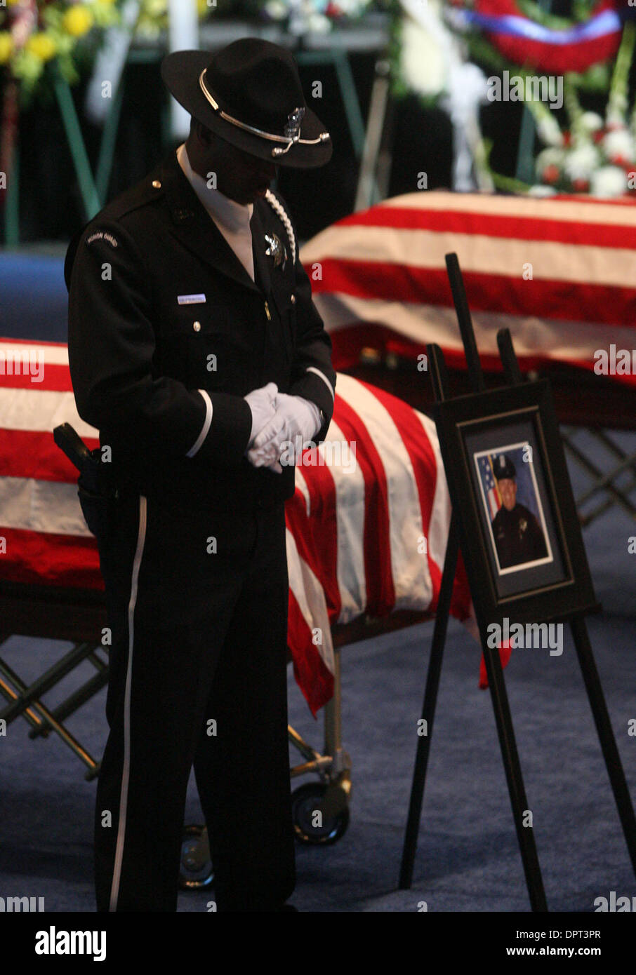An officer stands guard at the casket of Sgt Mark Dunakin on Friday ...