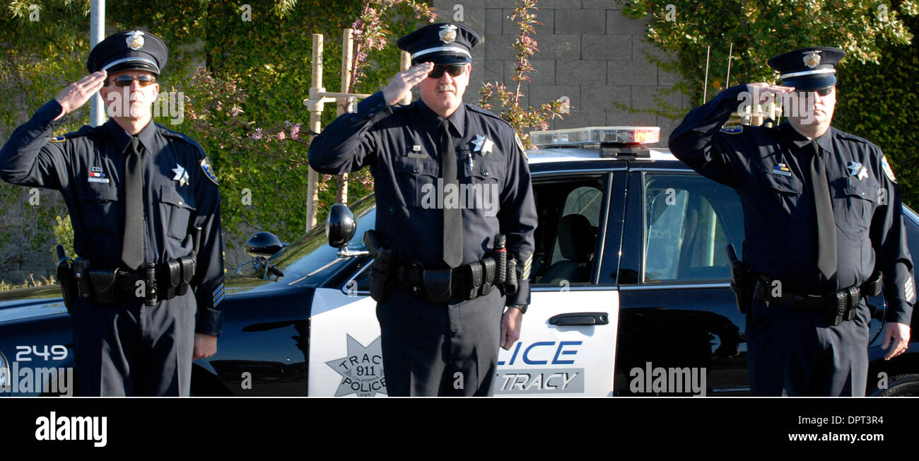Members of the Tracy Police salute as a hearse carrying the body of ...