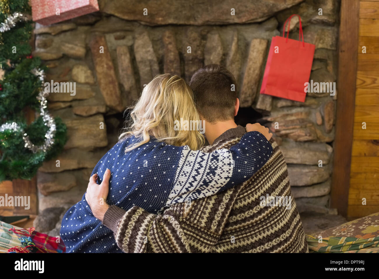Romantic couple embracing in front of fireplace Stock Photo - Alamy