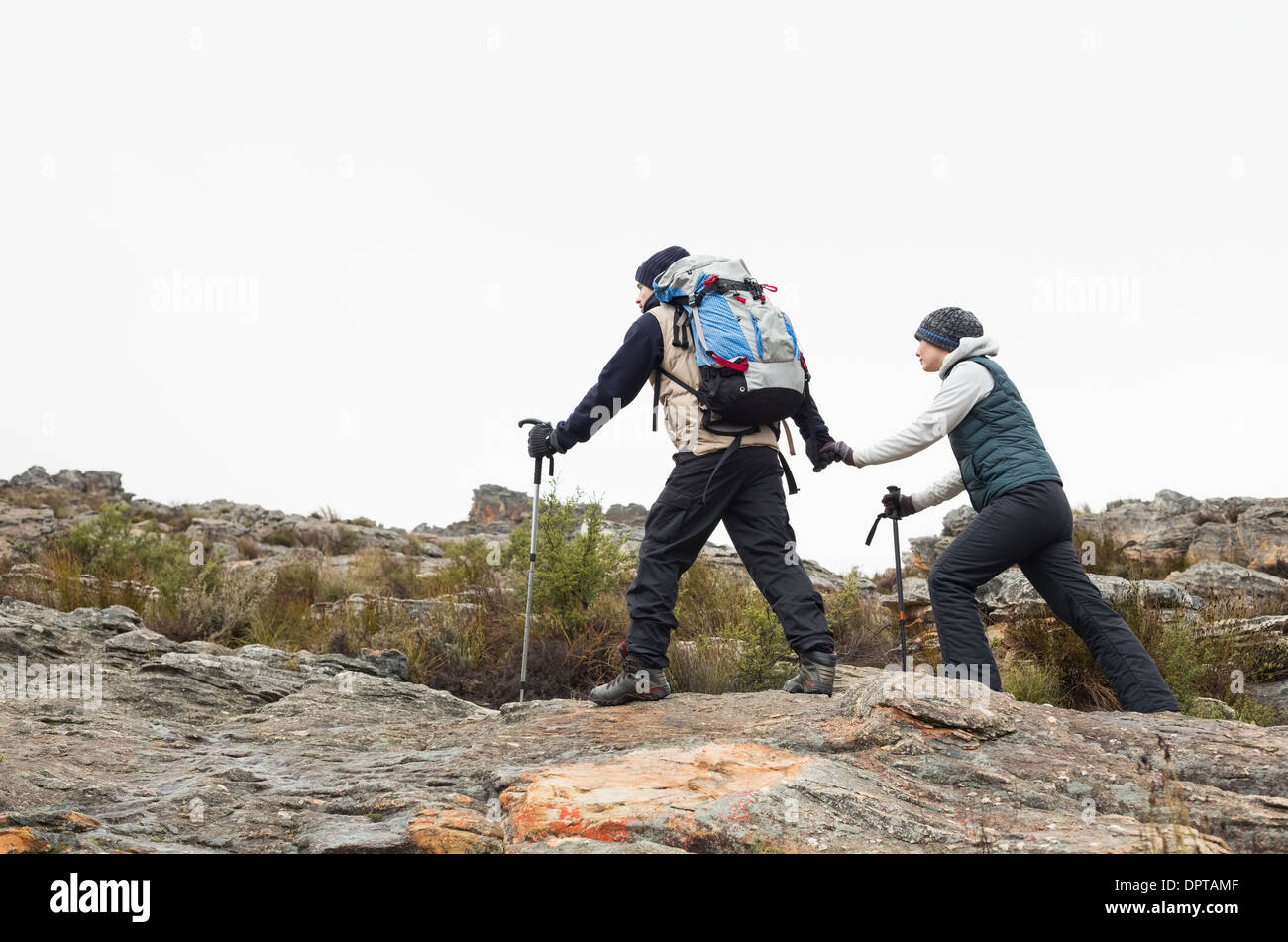 Couple walking on rocky landscape with trekking poles Stock Photo - Alamy