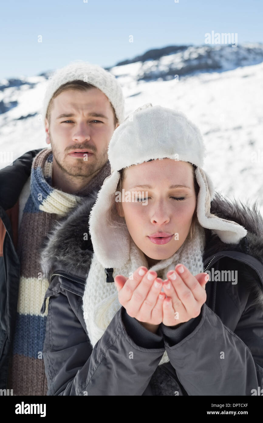 Couple with cupped hands on snow covered landscape Stock Photo - Alamy