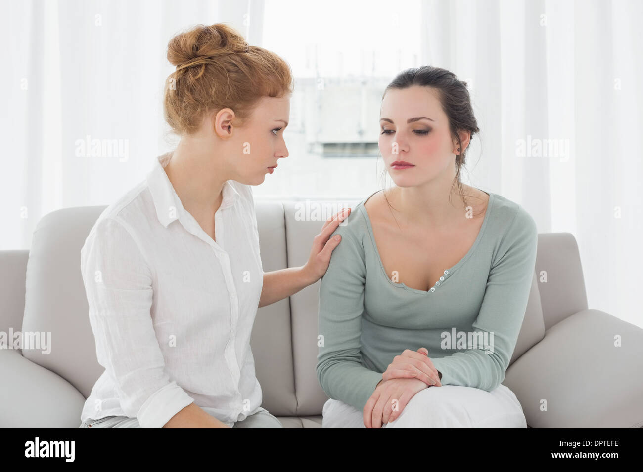 Young woman consoling female friend at home Stock Photo - Alamy