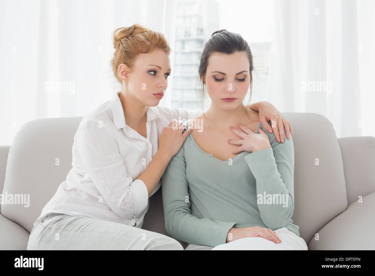 Young woman consoling female friend at home Stock Photo - Alamy