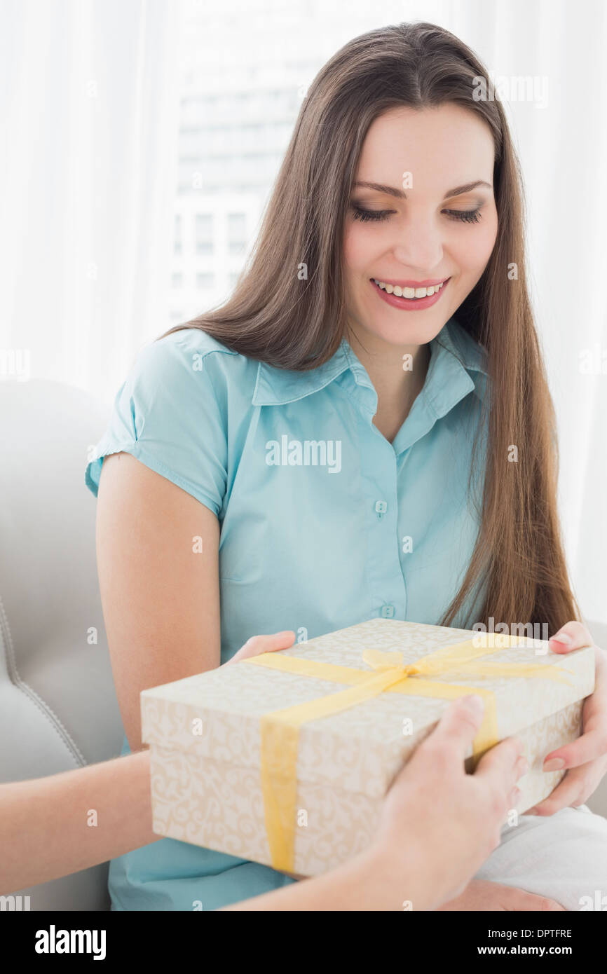Beautiful brunette receiving a gift box at home Stock Photo - Alamy