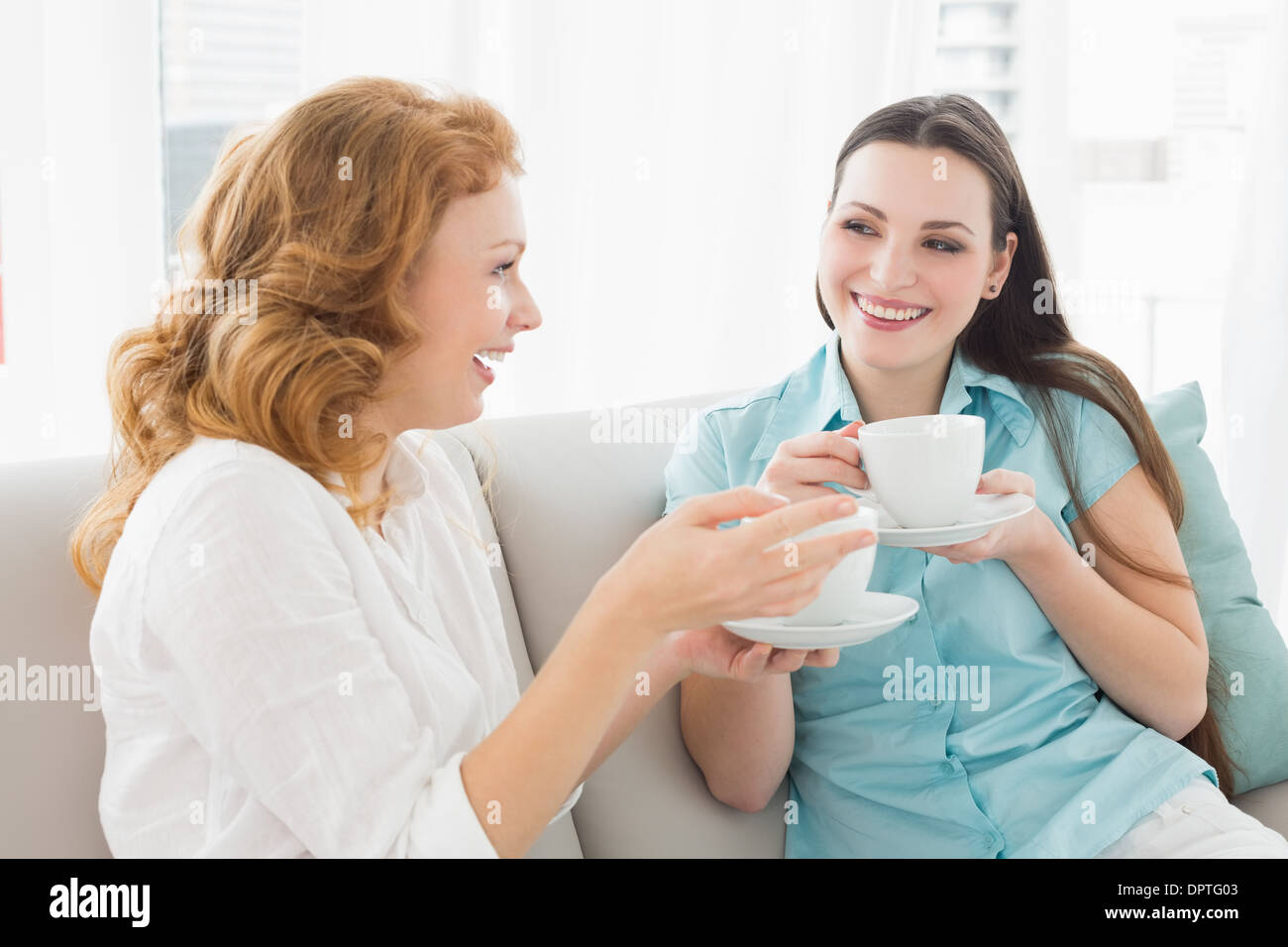 Friends with coffee cups enjoying a conversation at home Stock Photo ...