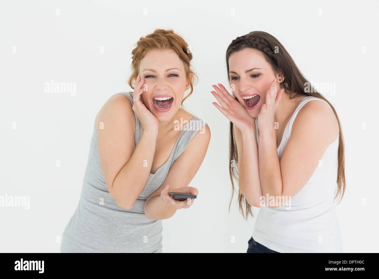 Shocked cheerful female friends with mobile phone Stock Photo - Alamy