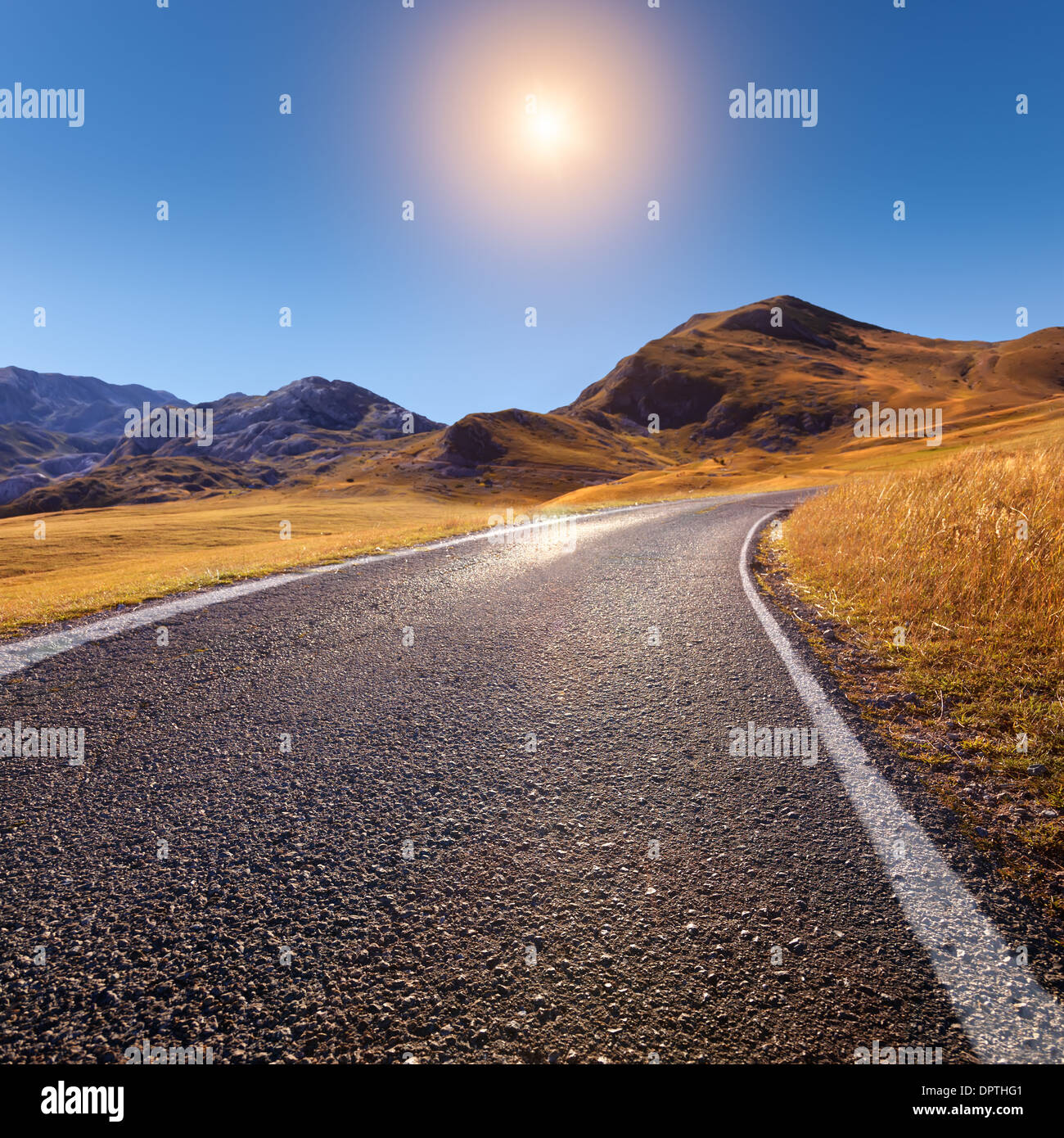 Driving on an empty mountain road to the sun Stock Photo - Alamy