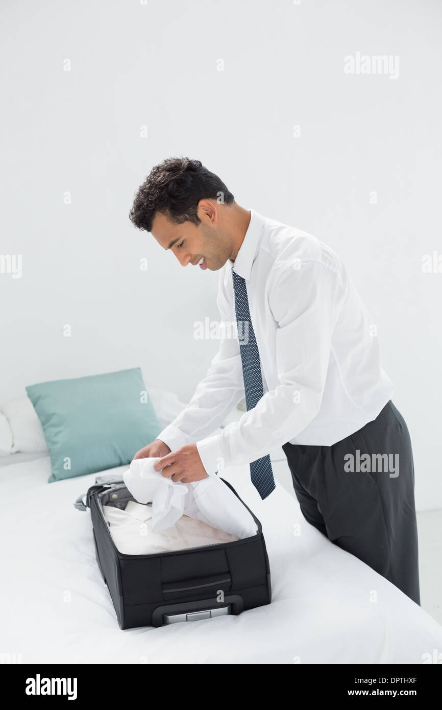 Businessman unpacking luggage at a hotel bedroom Stock Photo - Alamy