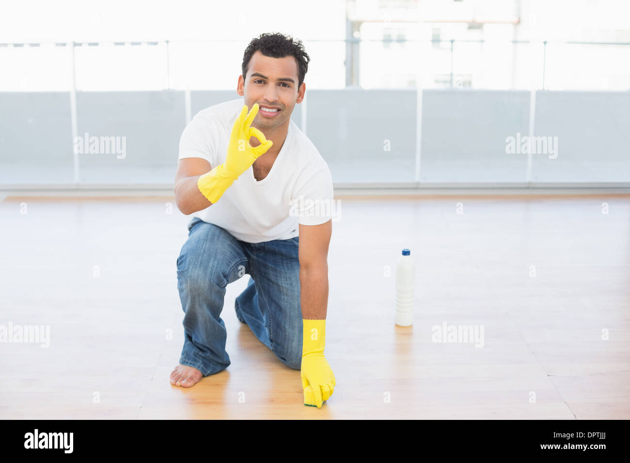 Smiling man cleaning the floor while gesturing okay sign Stock Photo ...