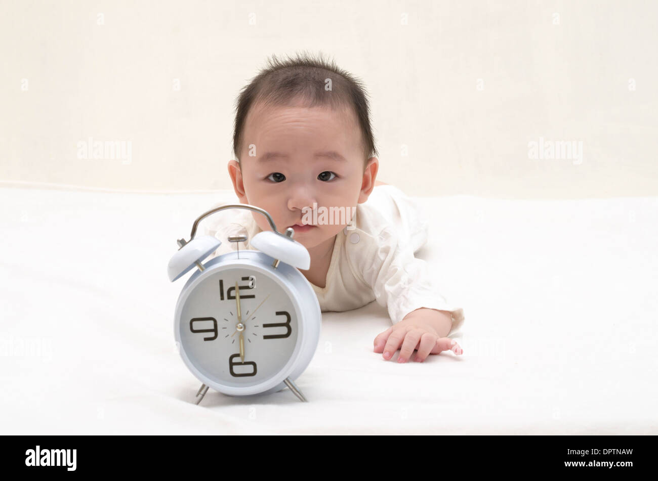 Baby with clock Stock Photo - Alamy