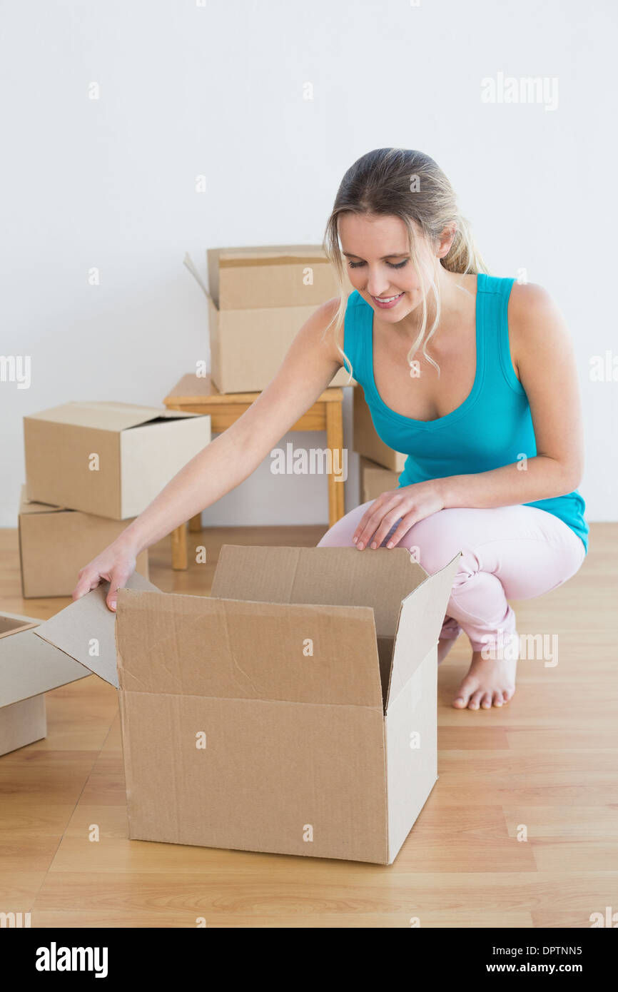 Woman unwrapping boxes in new house Stock Photo - Alamy