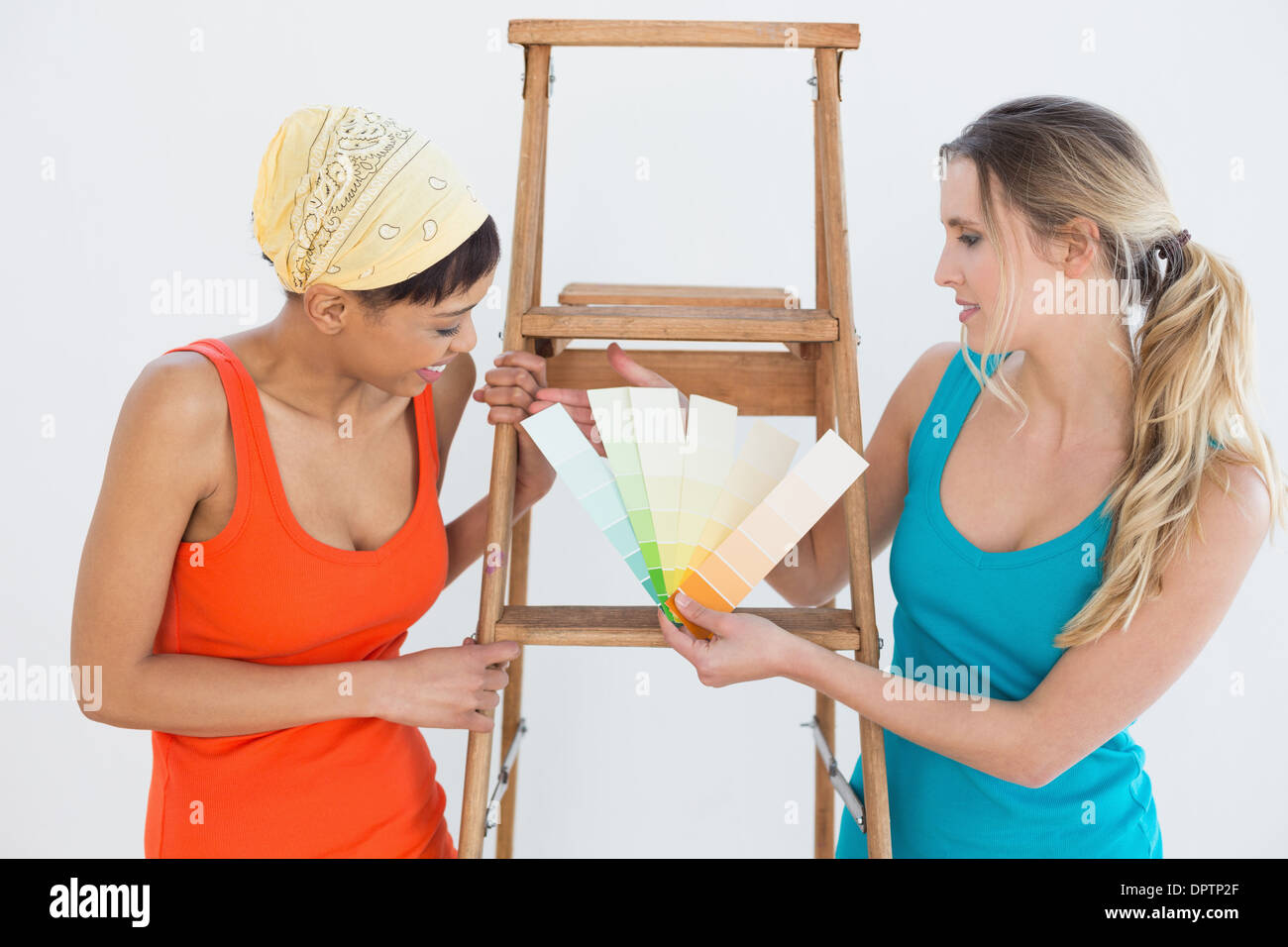 Friends with ladder choosing color for painting a room Stock Photo - Alamy