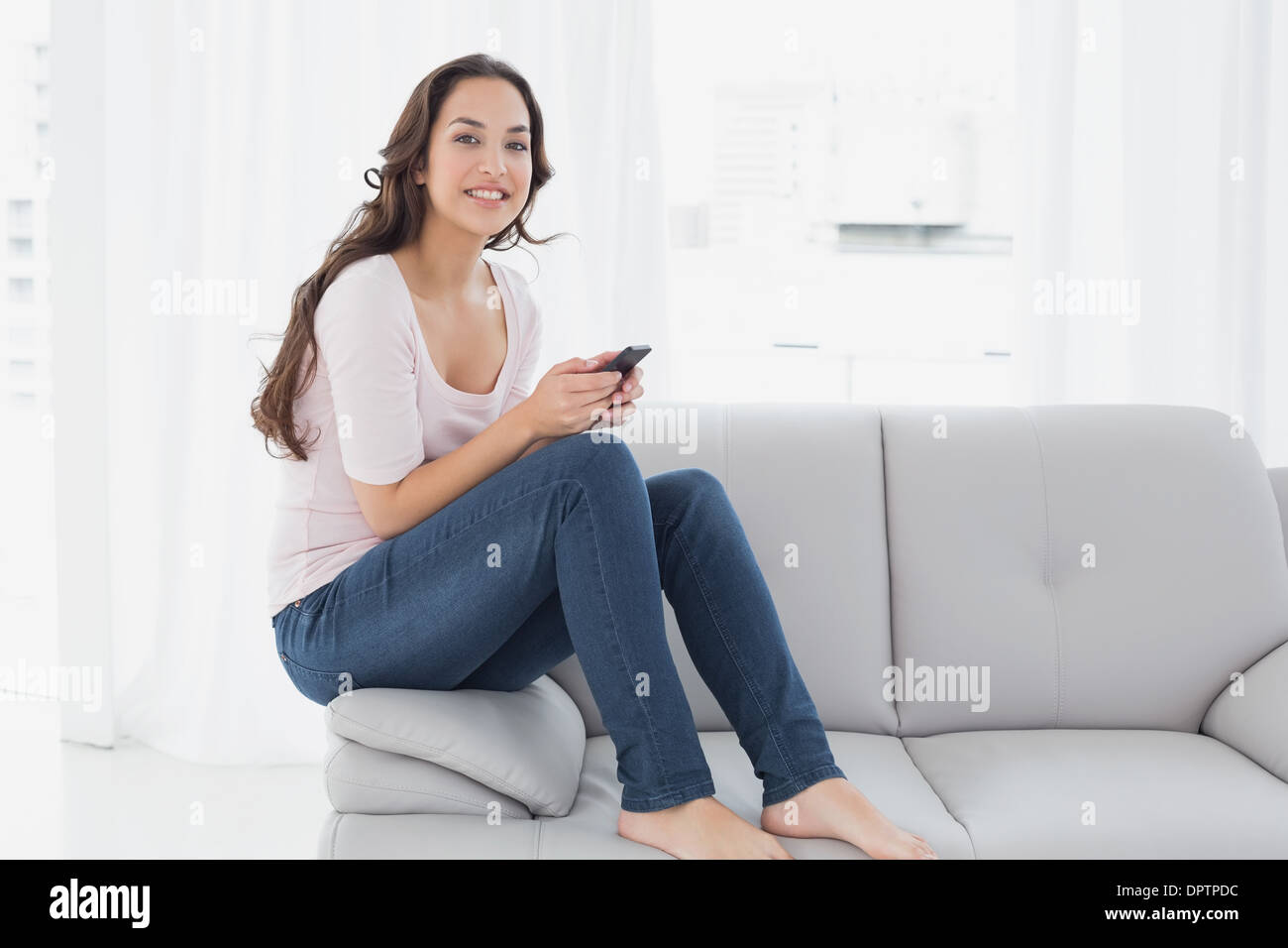 Relaxed woman text messaging on sofa at home Stock Photo - Alamy