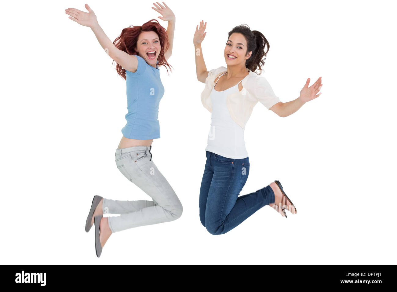 Portrait of two cheerful young female friends jumping Stock Photo - Alamy