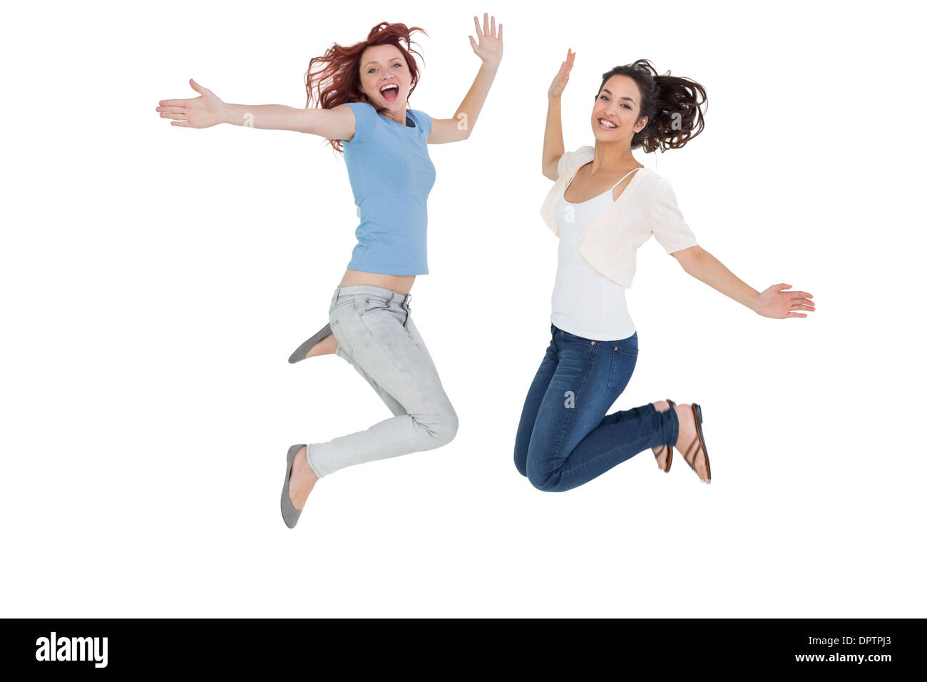Two cheerful young female friends jumping Stock Photo - Alamy