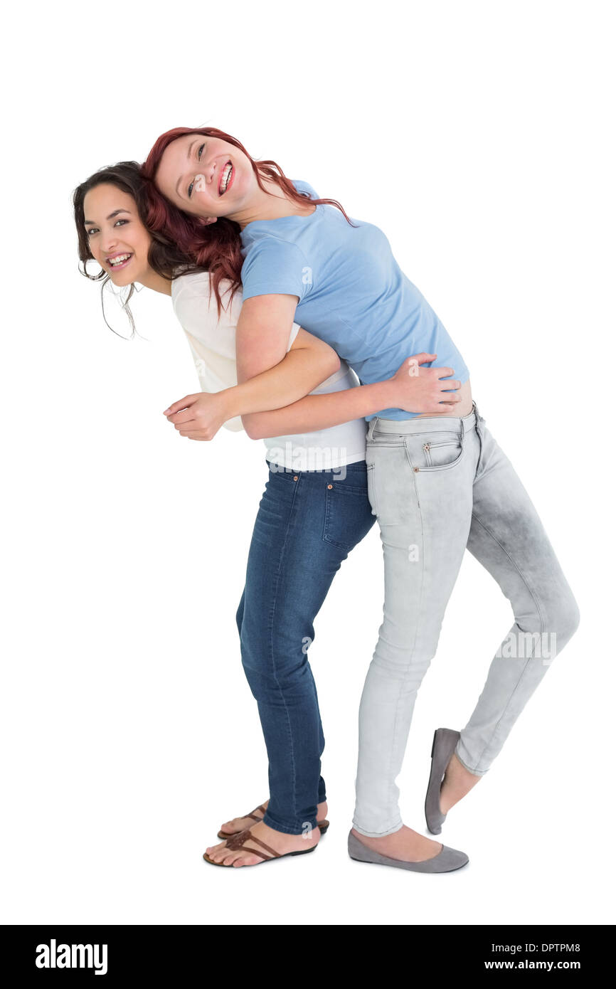 Young woman carrying female friend on back Stock Photo - Alamy