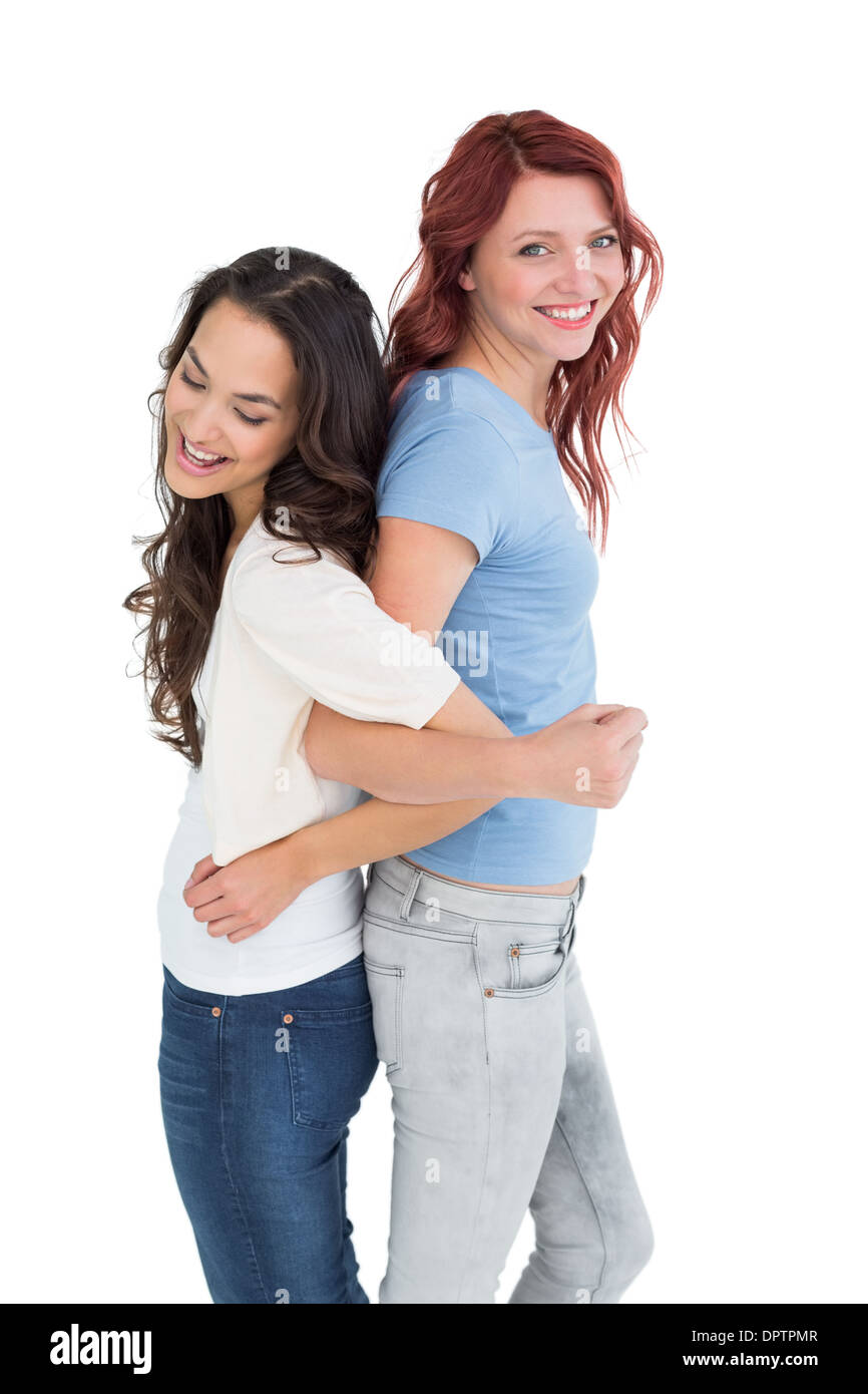 Young women standing back to back with interlocked hands Stock Photo ...