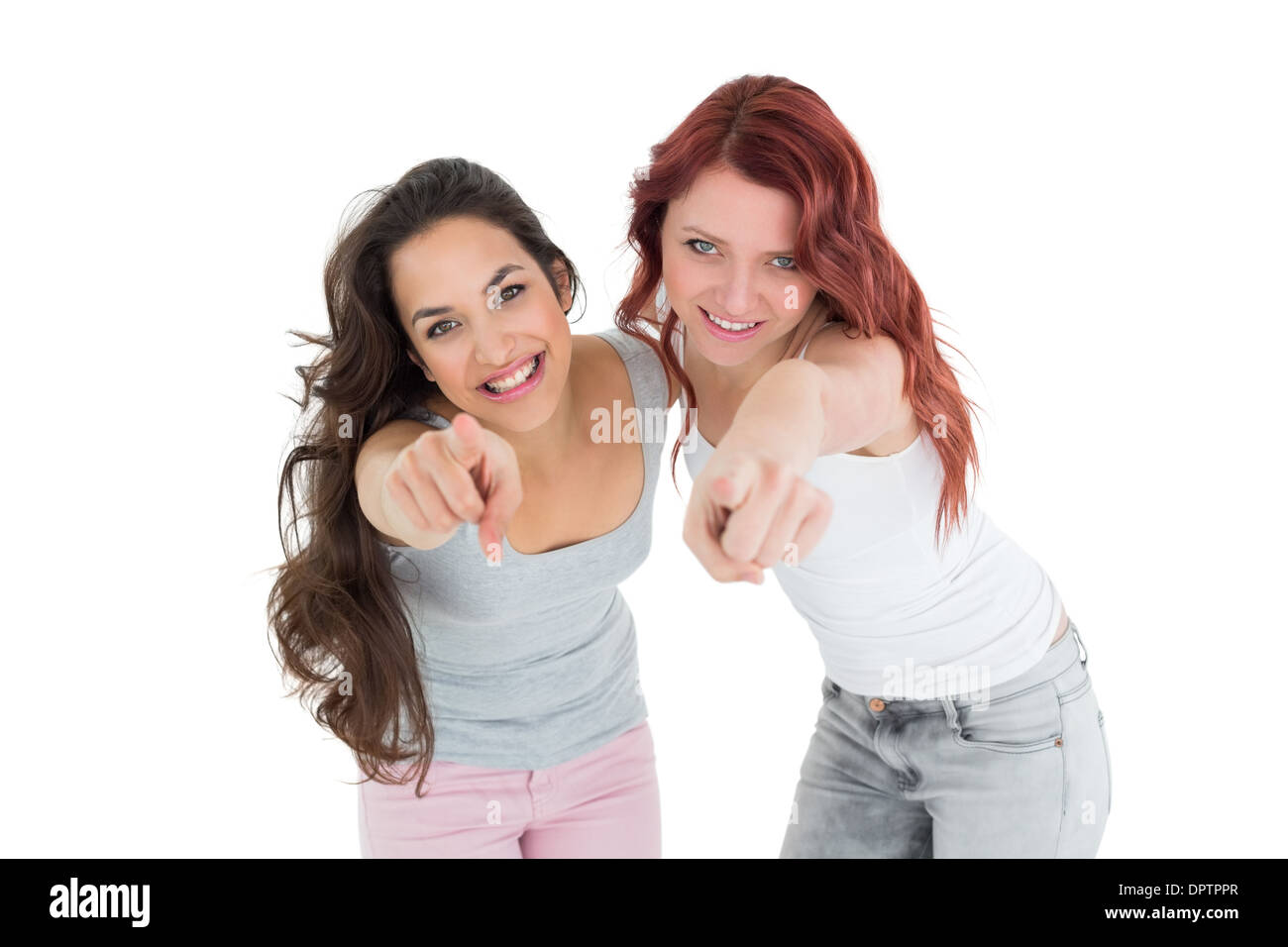 Happy young friends pointing against white background Stock Photo - Alamy