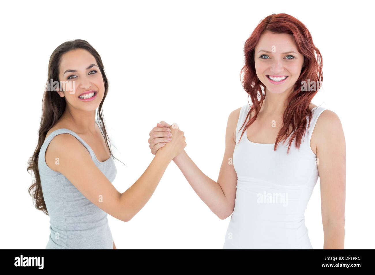 Two cheerful young female friends arm wrestling Stock Photo - Alamy