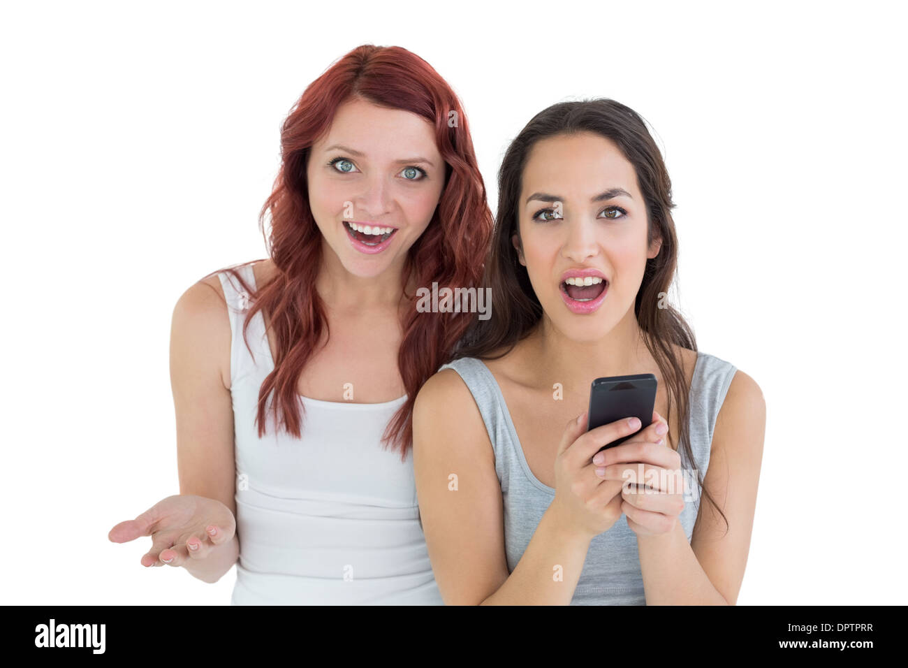 Shocked casual young female friends with mobile phone Stock Photo - Alamy