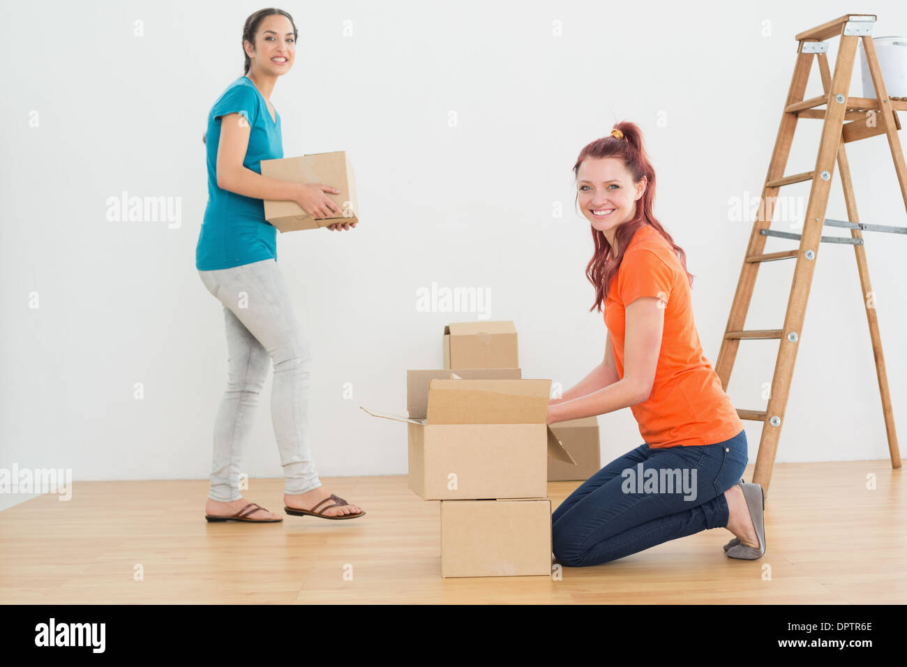 Portrait of two friends moving together in a new house Stock Photo - Alamy