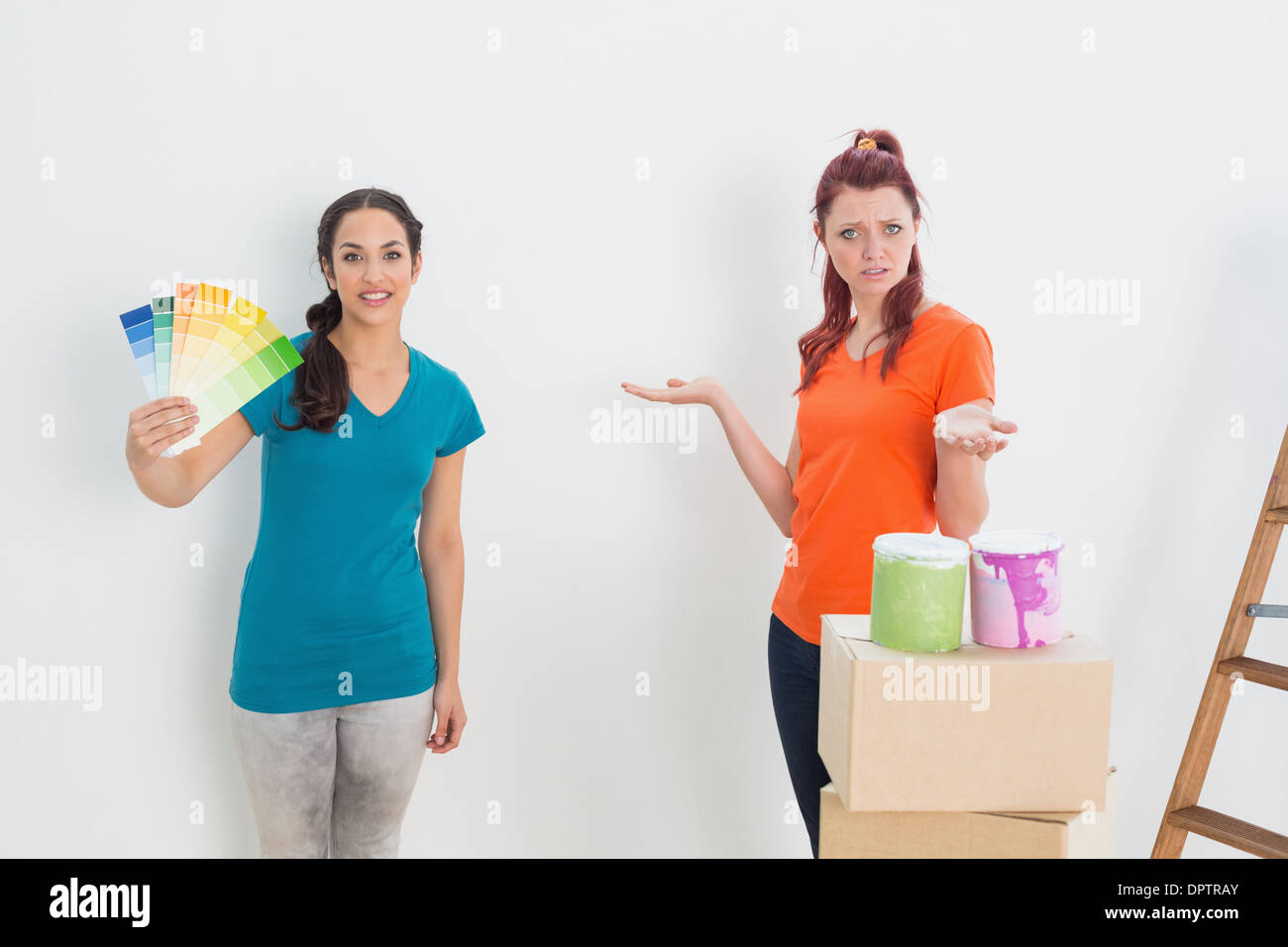 Confused friends choosing color for painting a room Stock Photo - Alamy