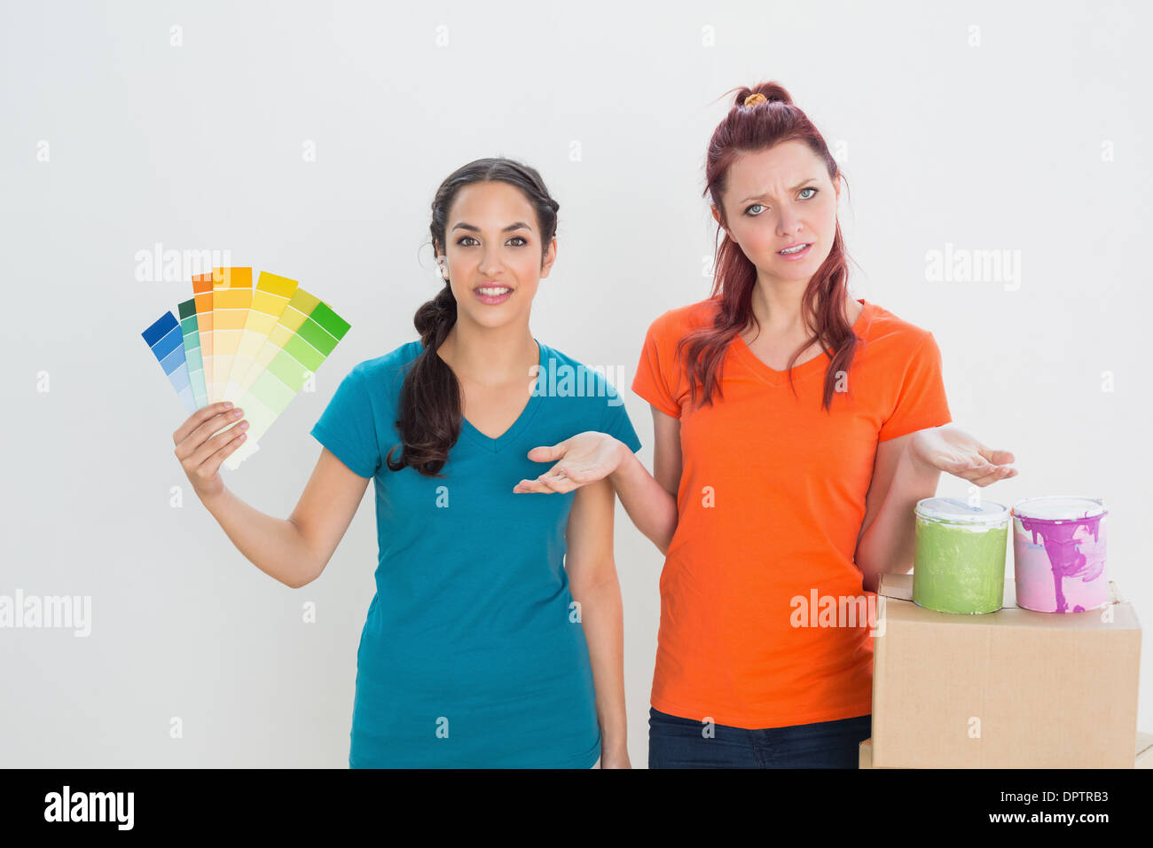 Confused friends choosing color for painting a room Stock Photo - Alamy