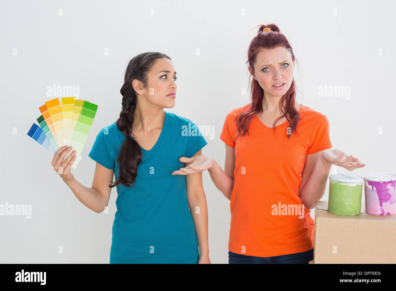 Confused friends choosing color for painting a room Stock Photo - Alamy