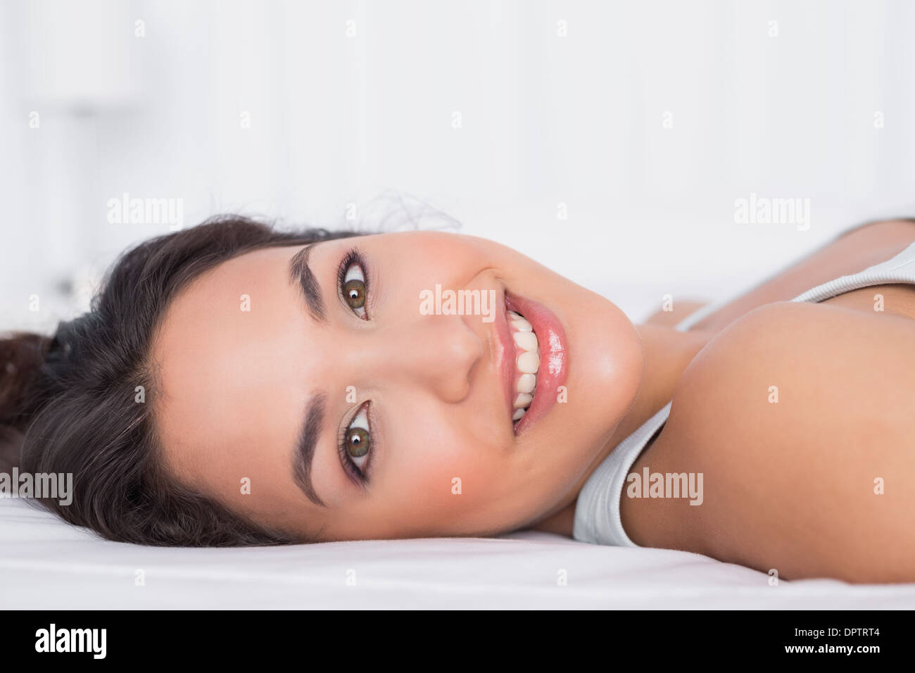 Smiling pretty young woman relaxing in bed Stock Photo - Alamy