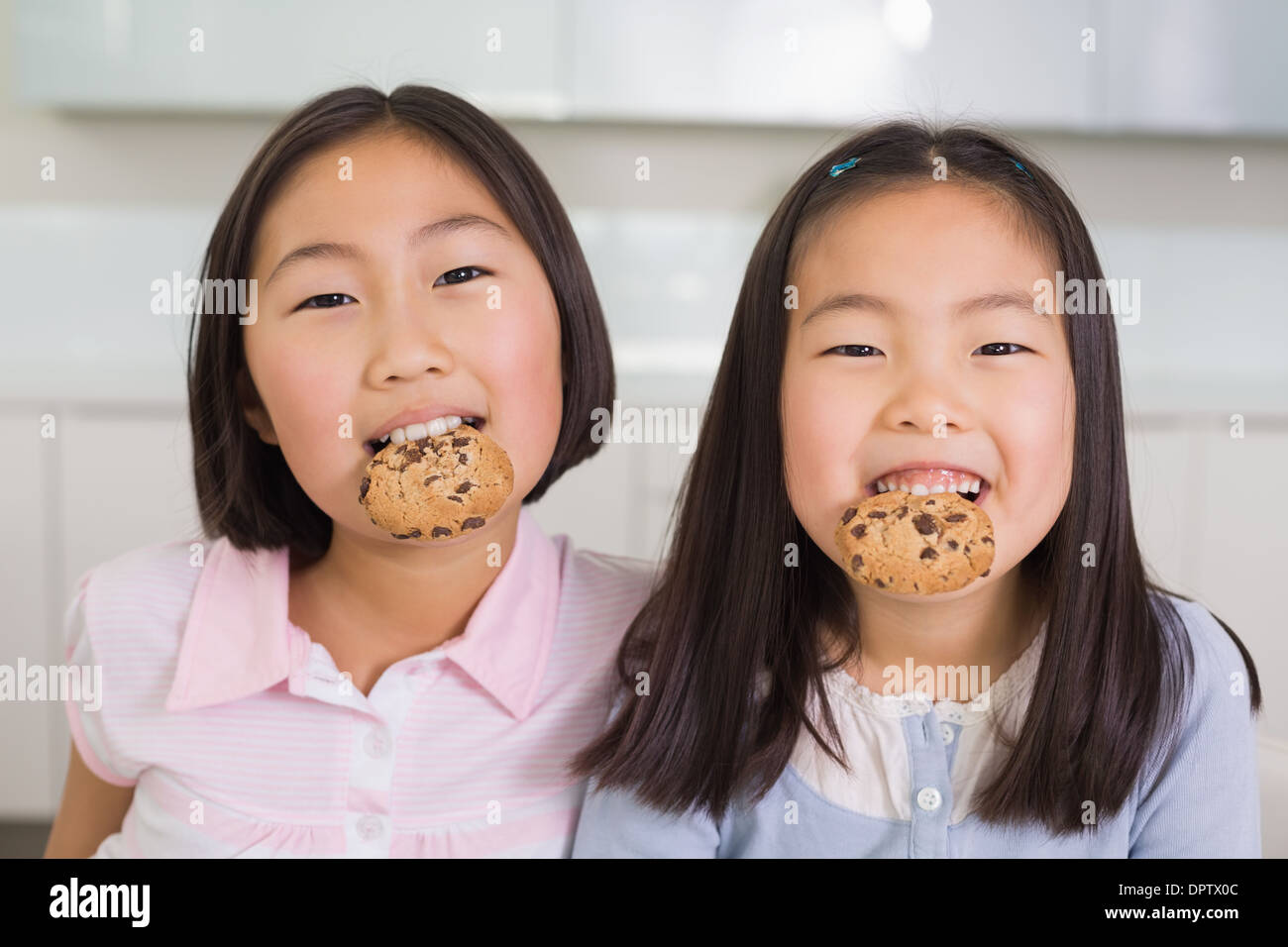 Portrait of two smiling young girls enjoying cookies Stock Photo - Alamy