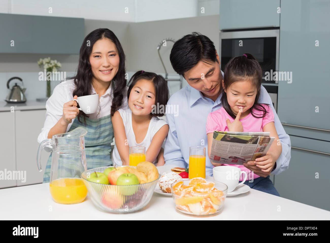 Family of four enjoying healthy breakfast in kitchen Stock Photo - Alamy