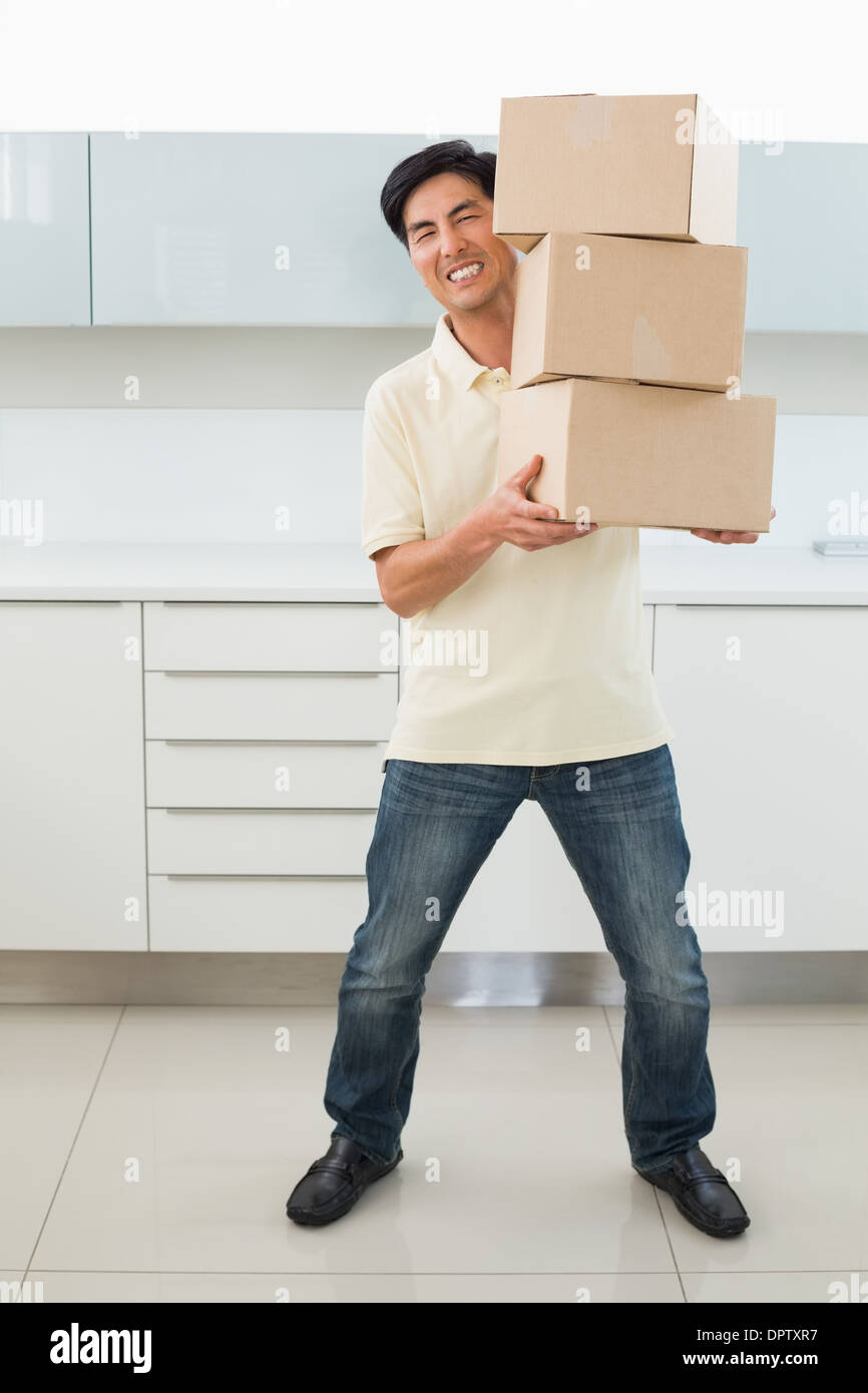 Full length of a casual young man carrying boxes Stock Photo - Alamy
