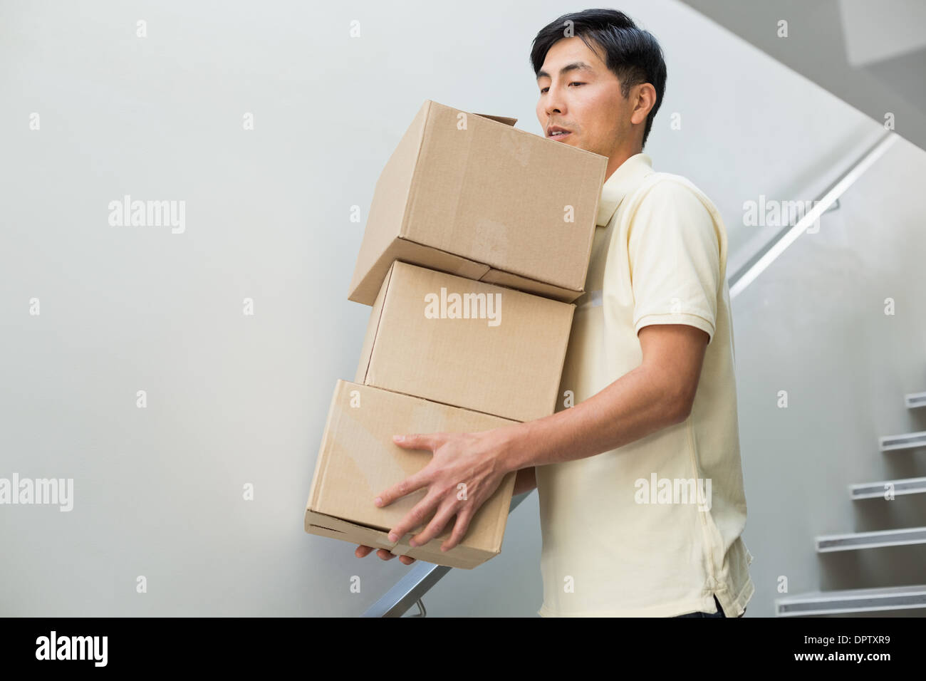 Young man carrying boxes Stock Photo - Alamy