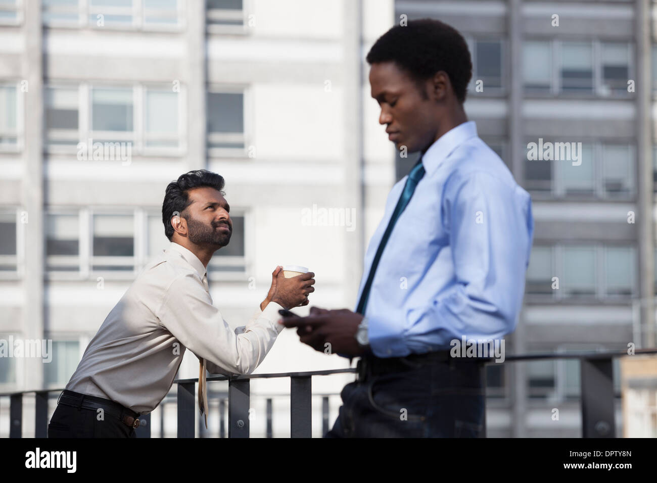Two businessmen taking time out on roof terrace Stock Photo - Alamy