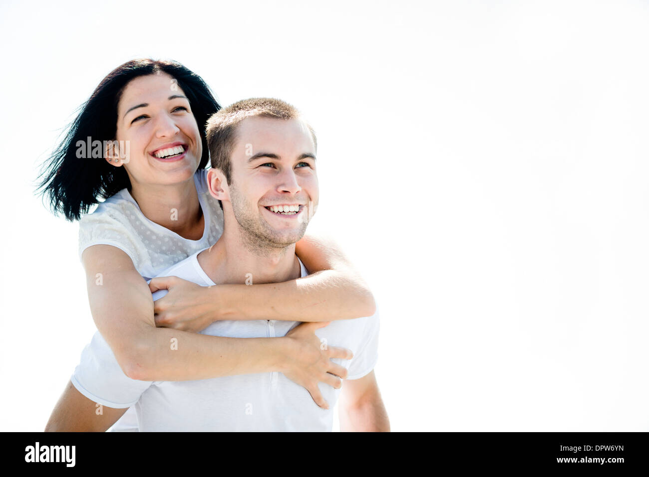 Happy young couple - smiling woman embbracing her boyfriend around neck ...