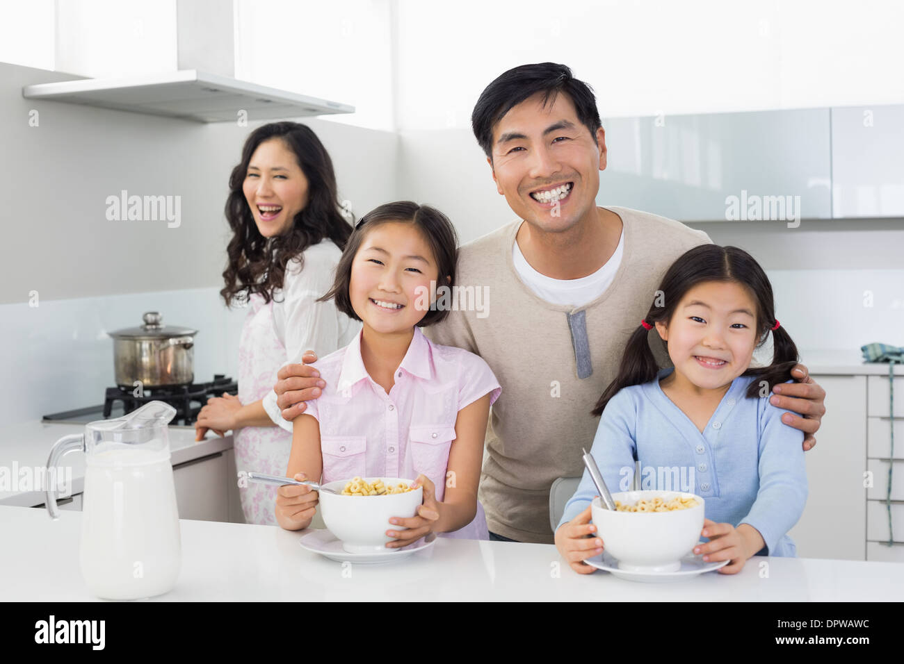 Family of four having breakfast in the kitchen Stock Photo - Alamy