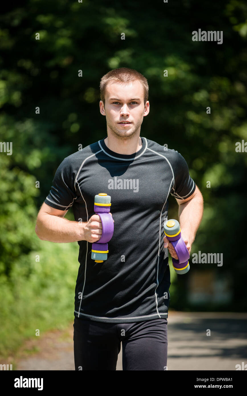 Running in nature - young man training with barbells Stock Photo - Alamy