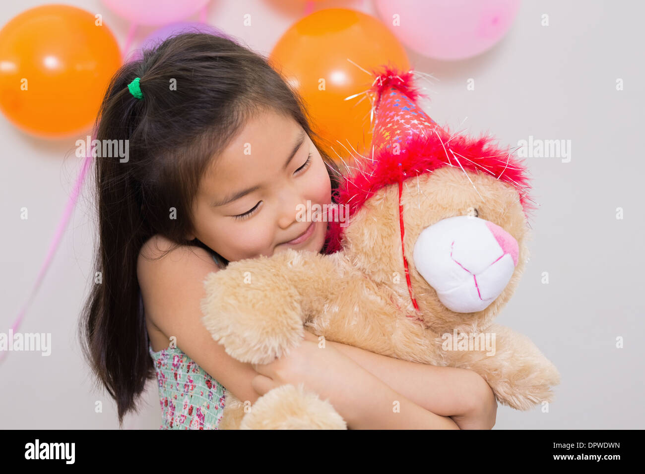 Cute girl hugging soft toy at a birthday party Stock Photo - Alamy