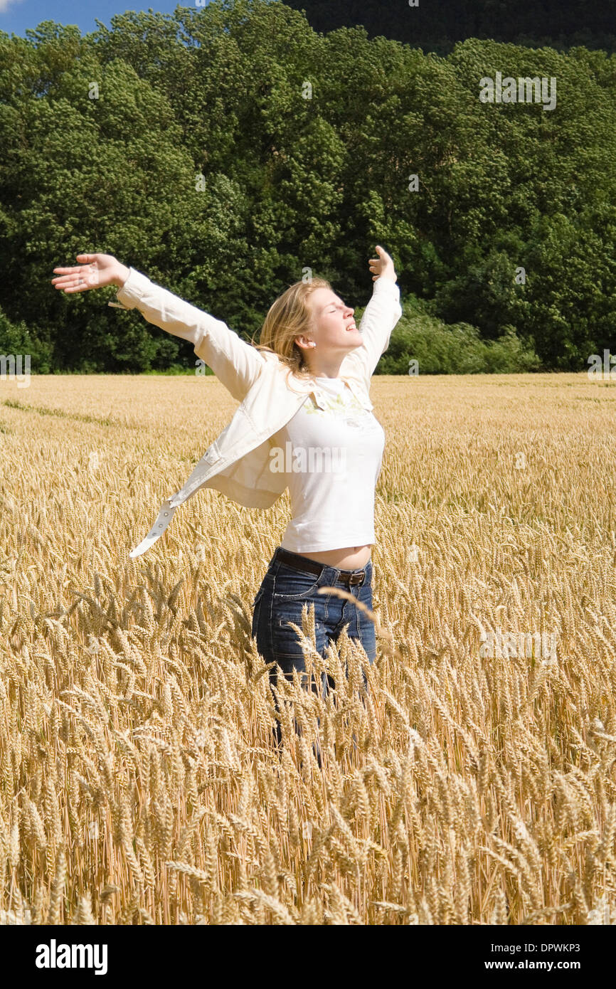 Woman standing in a grain field Stock Photo - Alamy