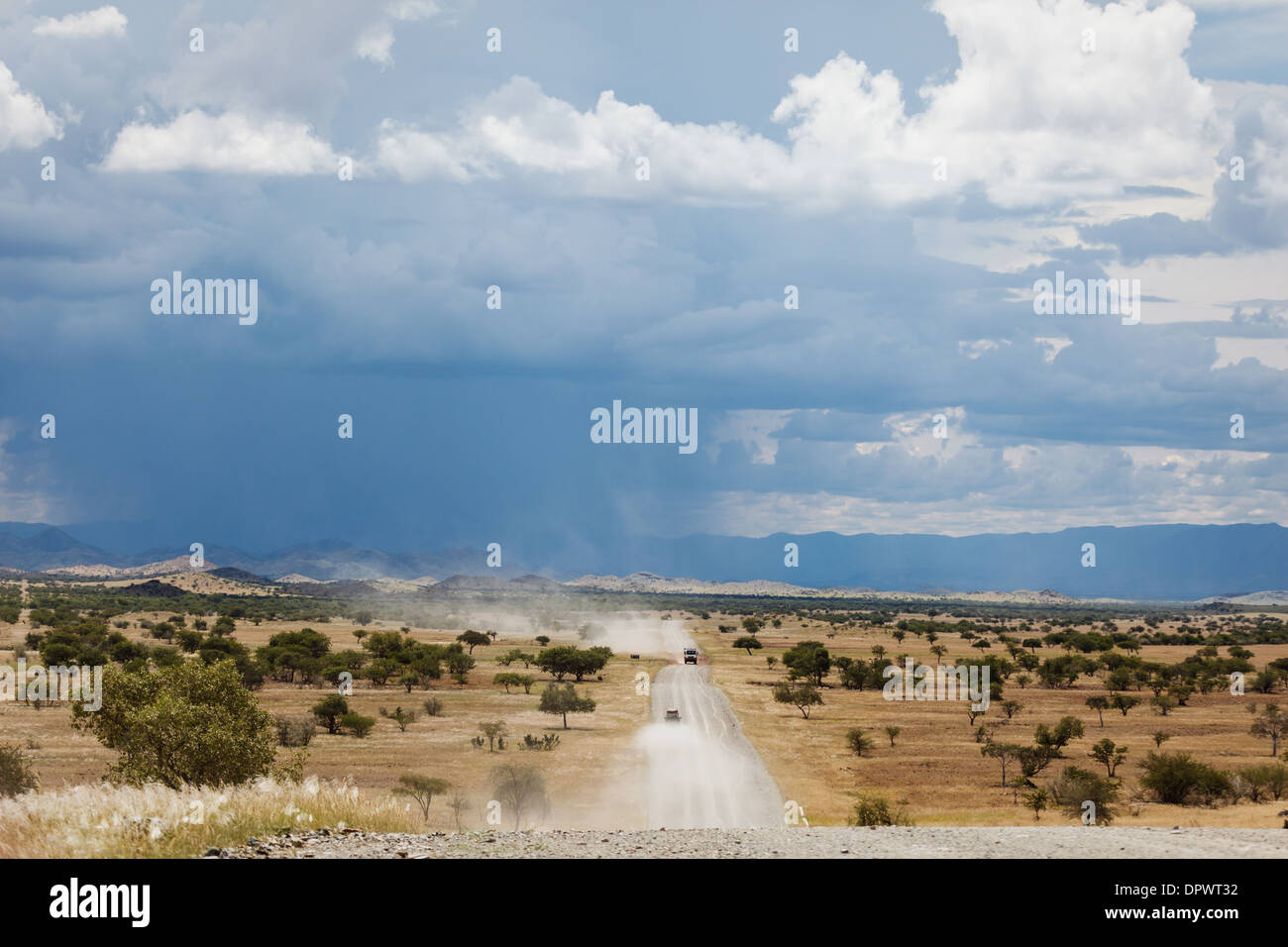 Dust from and approaching vehicle and a rainstorm mark the landscape in ...