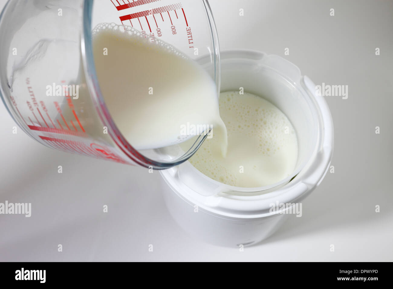 Adding milk to a yoghurt maker Stock Photo - Alamy