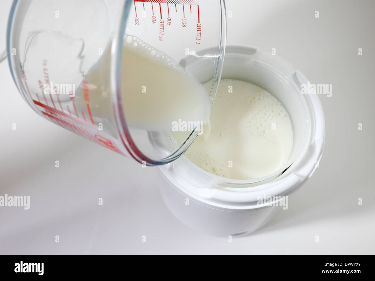 Adding milk to a yoghurt maker Stock Photo - Alamy