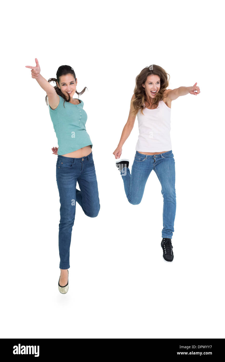 Two cheerful young female friends with hand gestures Stock Photo - Alamy